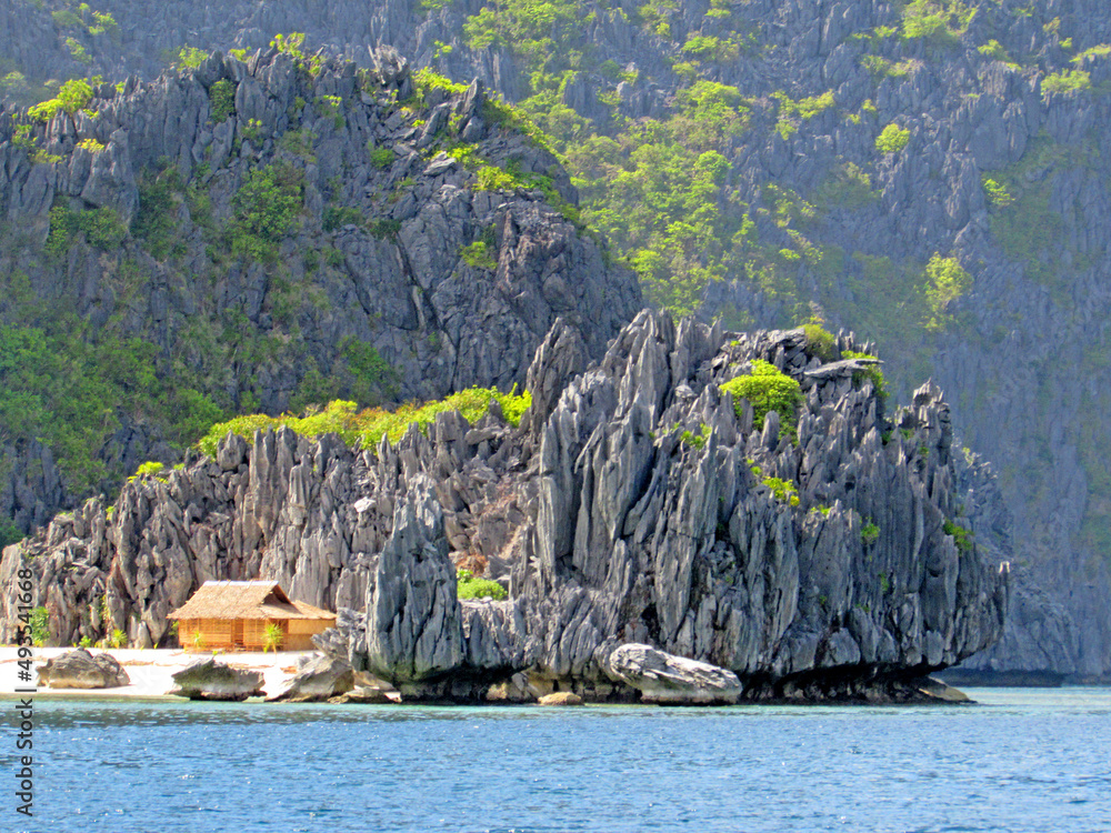 Traditional Filipino House with limestone rock background of an island ...