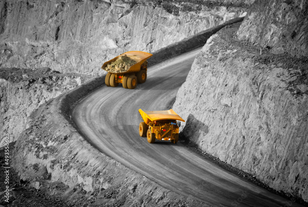 Two trucks in a modern gold mine in Australia. Spot colour large haul ...