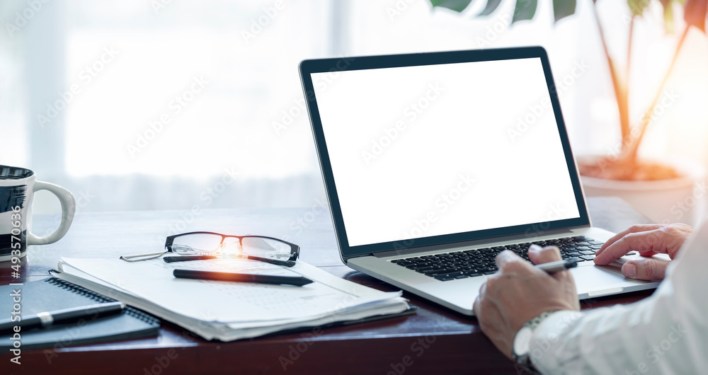 Businessman working on laptop computer at desk office, mockup blank ...