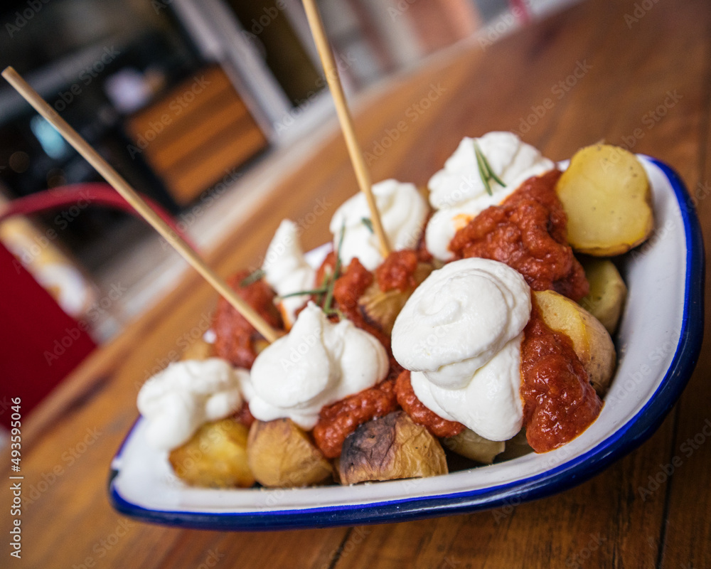 Ración de patatas bravas con salsa mayonesa, tomate concentrado y ...
