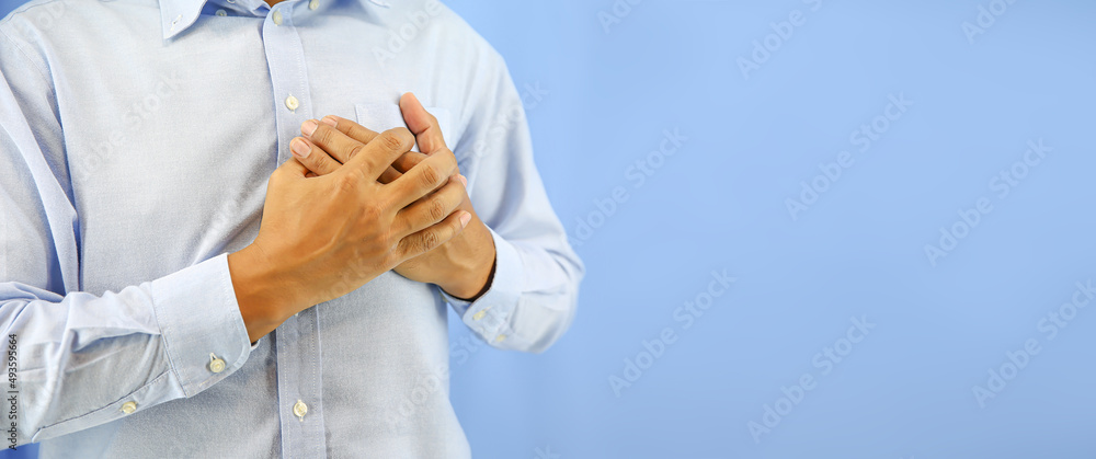Foto Stock Hand squeezing the left chest pain on blue background ...