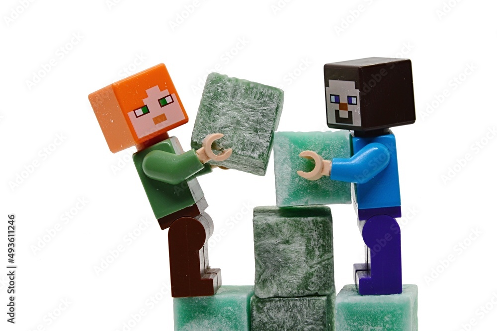 LEGO MInecraft figures of Steve and Alex building together a column ...