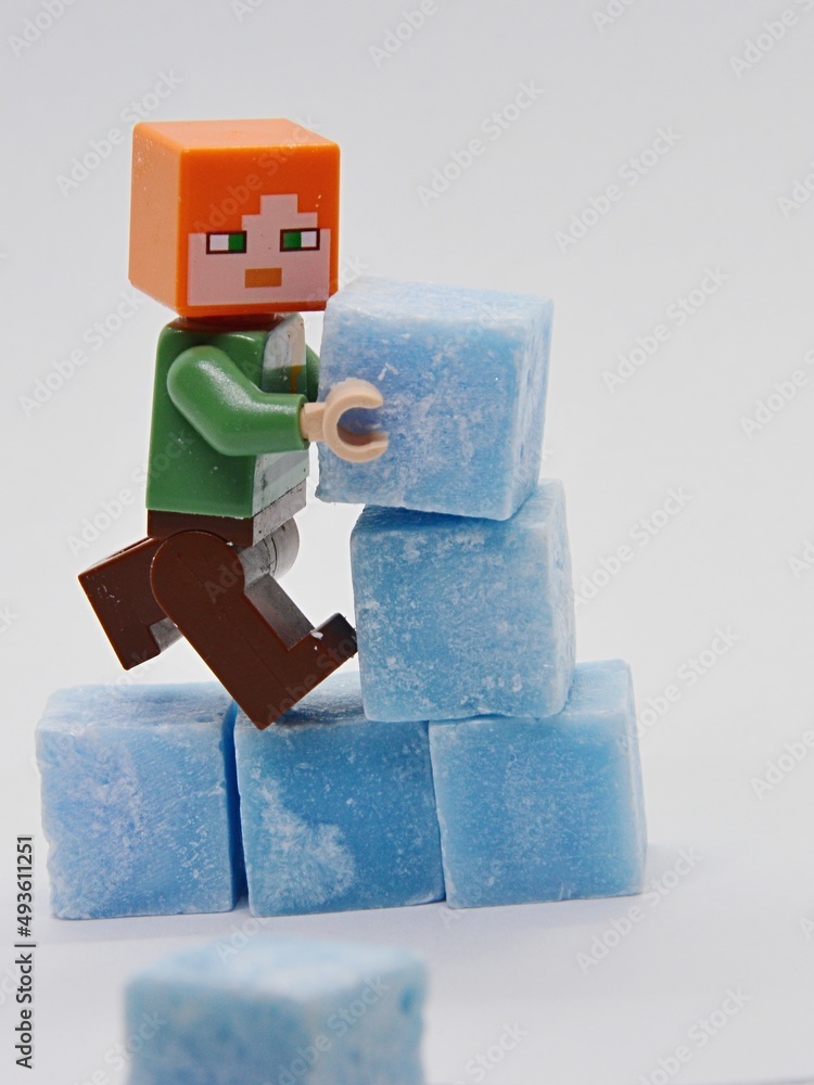 LEGO Minecraft figure of Alex is building third line of light blue of ...