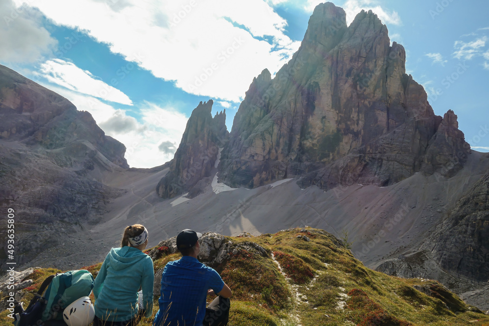 Couple sitting on the ground and resting under the foot of high Italian ...