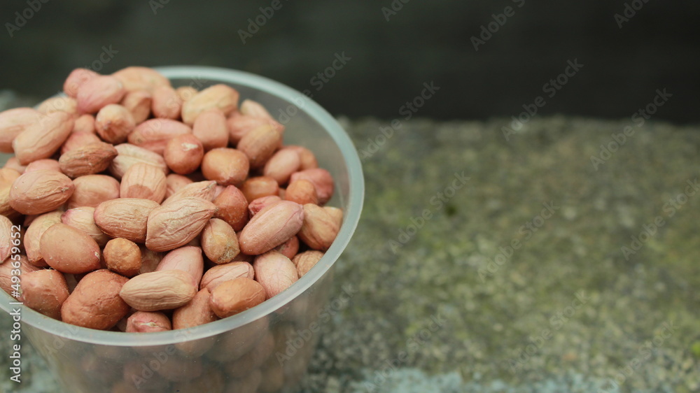 Salted Roasted Peanuts, Peeled raw peanuts are in a plastic cup ...