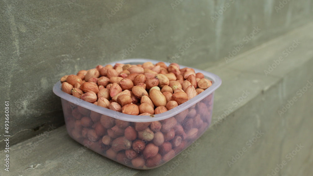 Salted Roasted Peanuts, Peeled raw peanuts are in a plastic cup ...