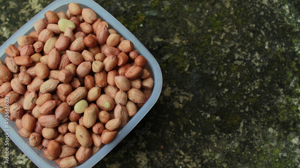 Salted Roasted Peanuts, Peeled raw peanuts are in a plastic cup ...