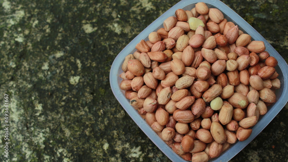 Salted Roasted Peanuts, Peeled raw peanuts are in a plastic cup ...