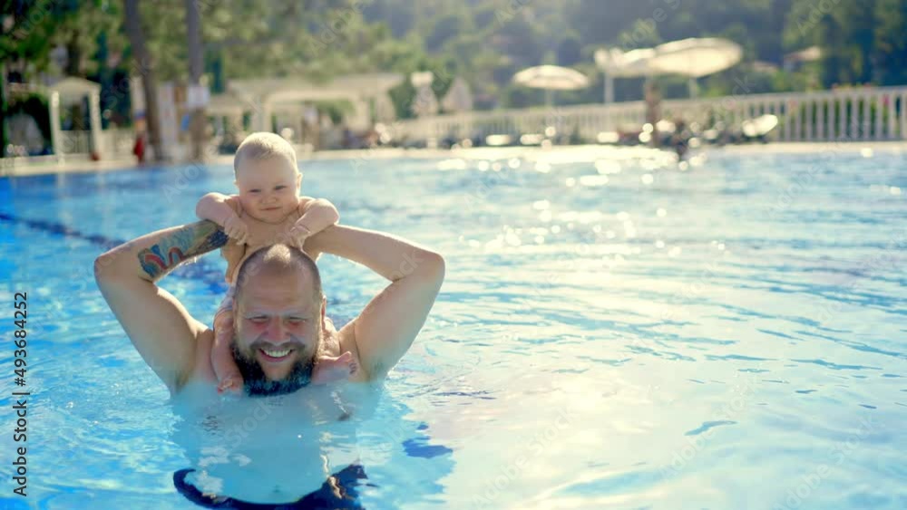 Cute baby having swimming lesson with his mother and father. Healthy ...