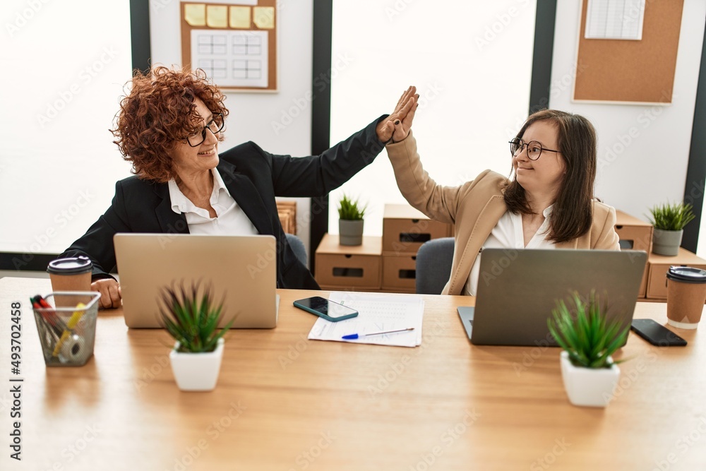 Group of two women working at the office. Mature woman and down ...