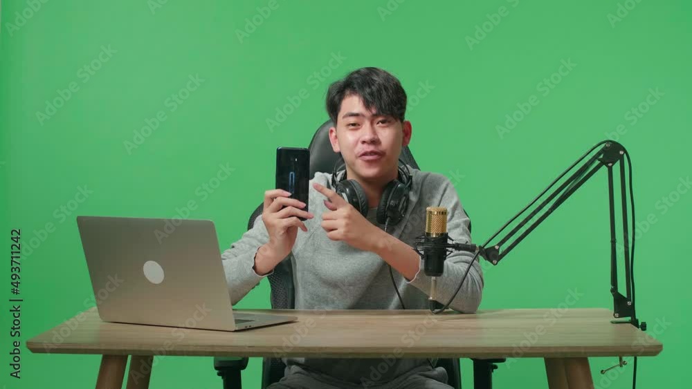 A Smiling Asian Man With Computer Reviewing Phone While Sitting In ...