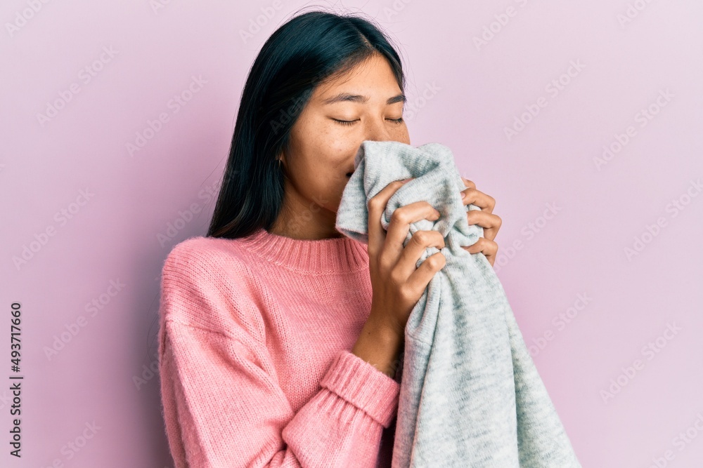 Young asian woman smelling laundry scent from clean sweater Stock Photo ...
