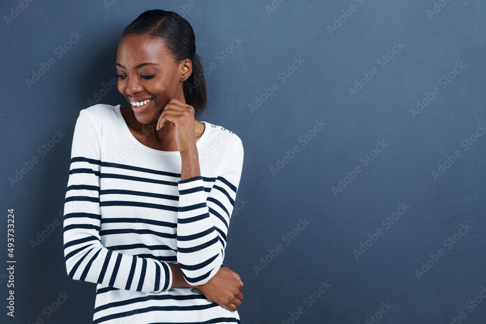 Shes on the shy side. Shot of an attractive young woman smiling shyly ...