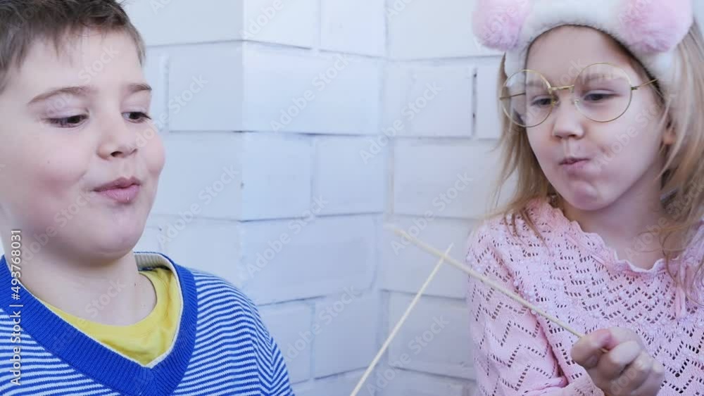 Vidéo Stock teenagers brother and sister feed each other with fried marshmallows on wooden ...