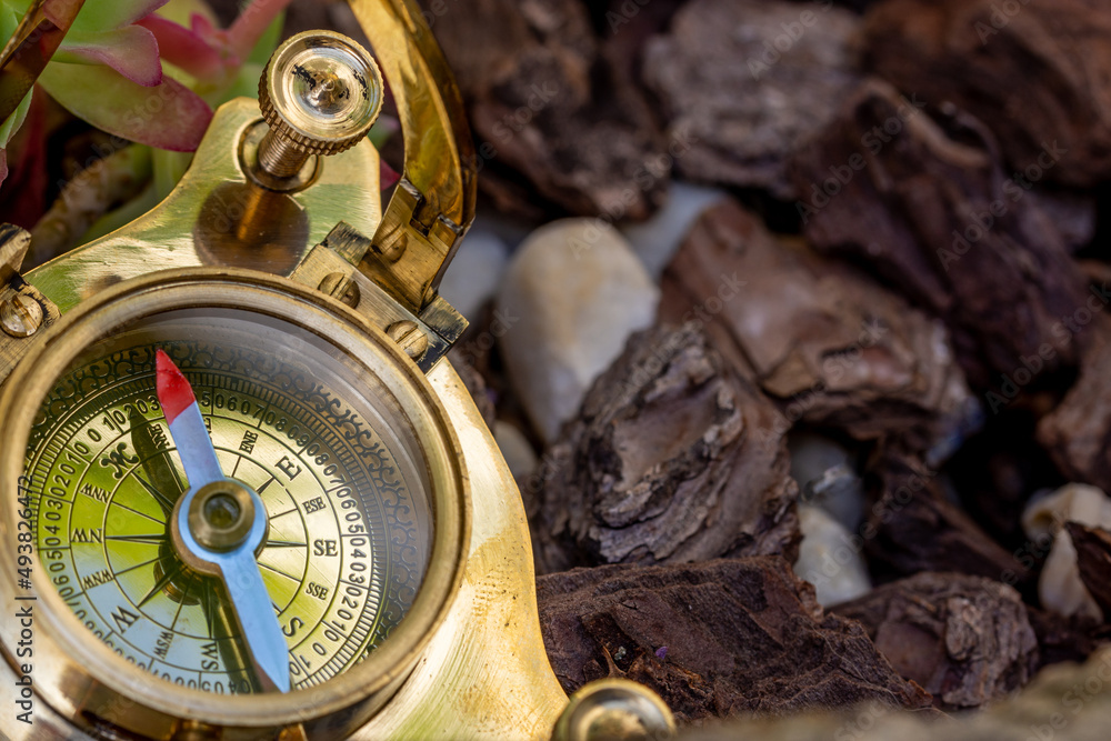 Detail of an antique maritime bronze solar compass on wood background ...