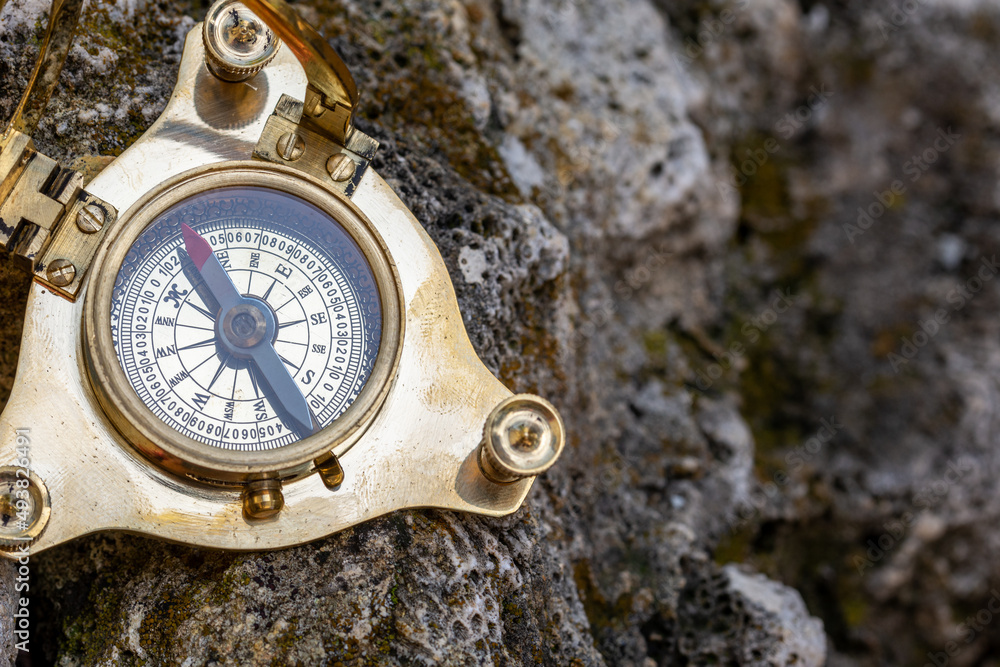 Detail of an antique maritime bronze solar compass on stone background ...