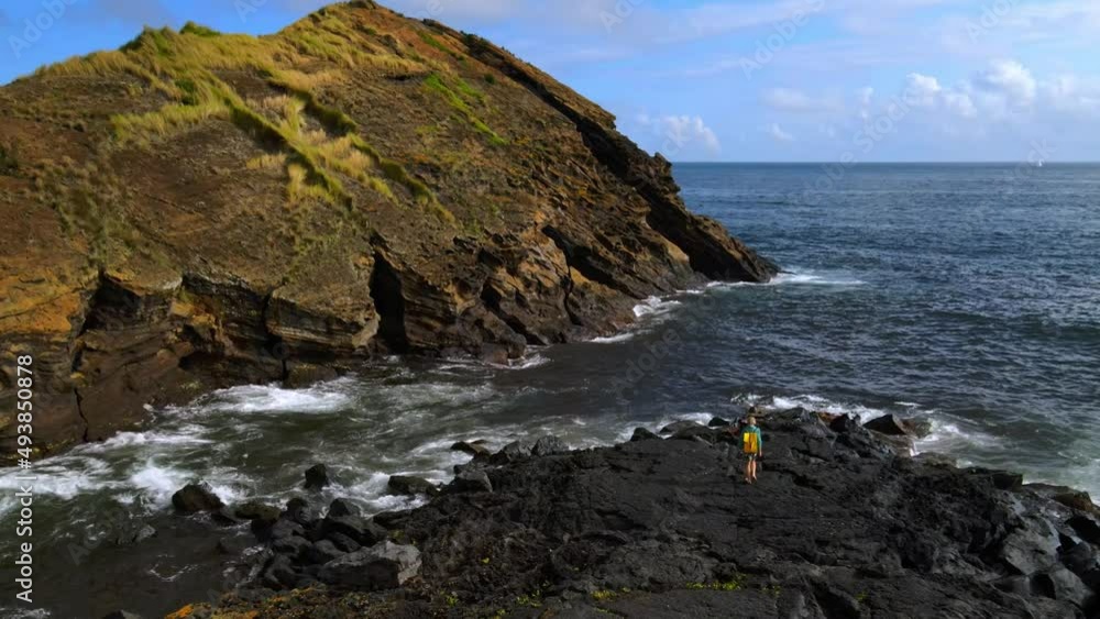 Girl wanders arround rocky black lava coastline in Azores. Volcanic ...