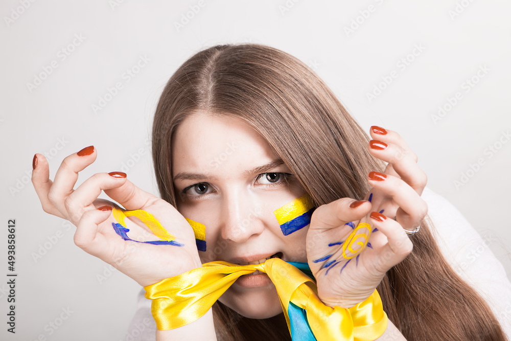 Angry young woman with a painted Ukrainian flag on her cheeks breaks ...