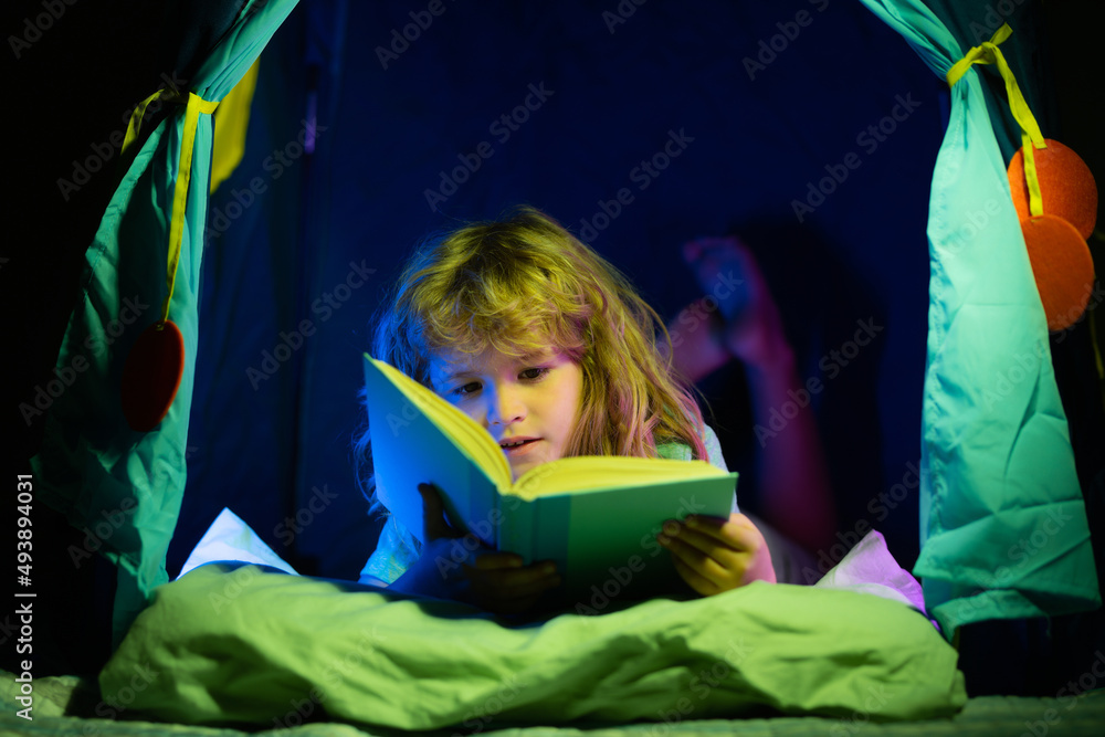 Kids reading books. Little boy in kids tentat home watching pictures in ...