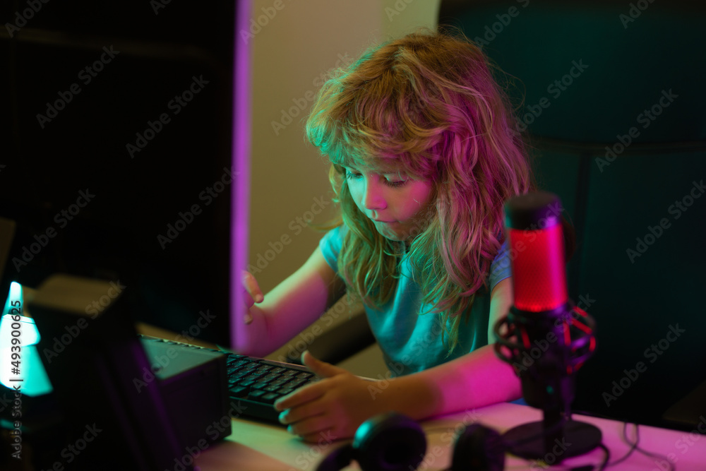 Little child gamer play computer game on desktop. Gaming stream and ...