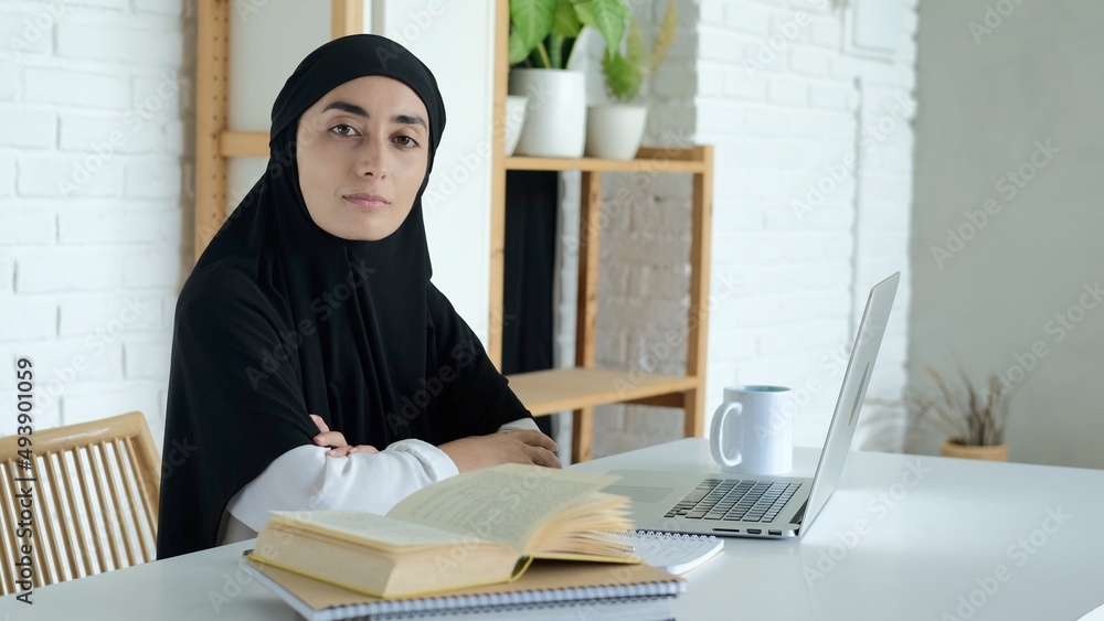 A female student in a hijab is undergoing distance learning. A Muslim ...