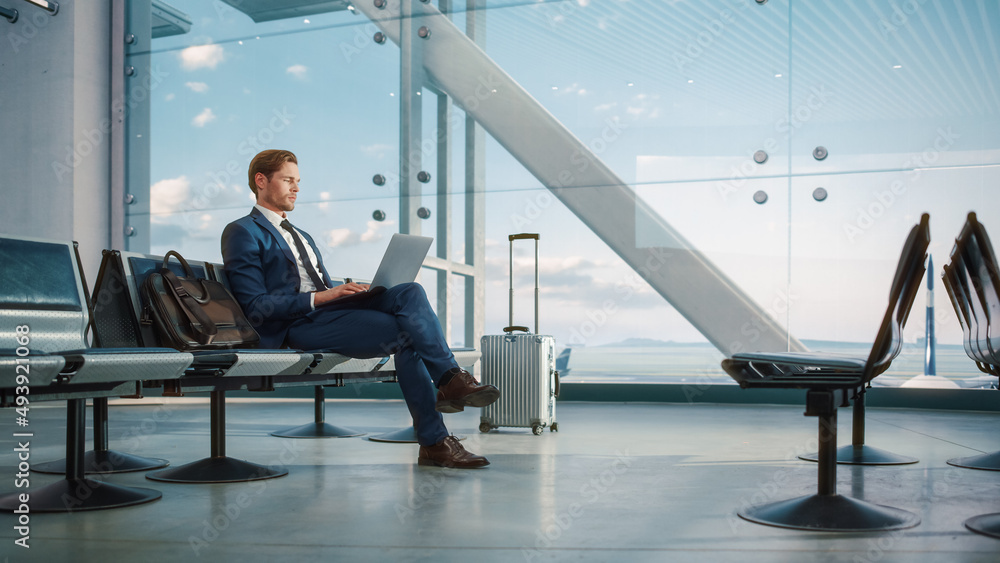 Airport Terminal: Businessman Uses Laptop Computer, Waiting for Flight ...