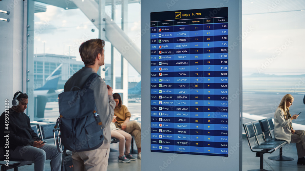 Airport Terminal: Young Man Looking at Arrival and Departure ...