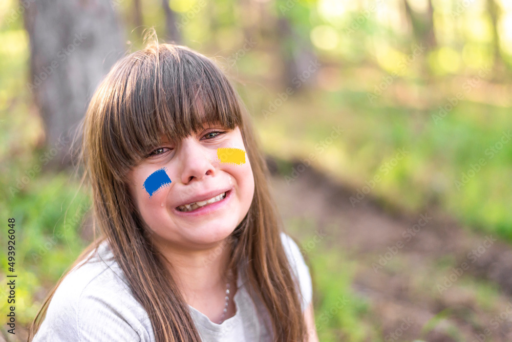 Scared child with devastated life crying in the woods, running from war ...