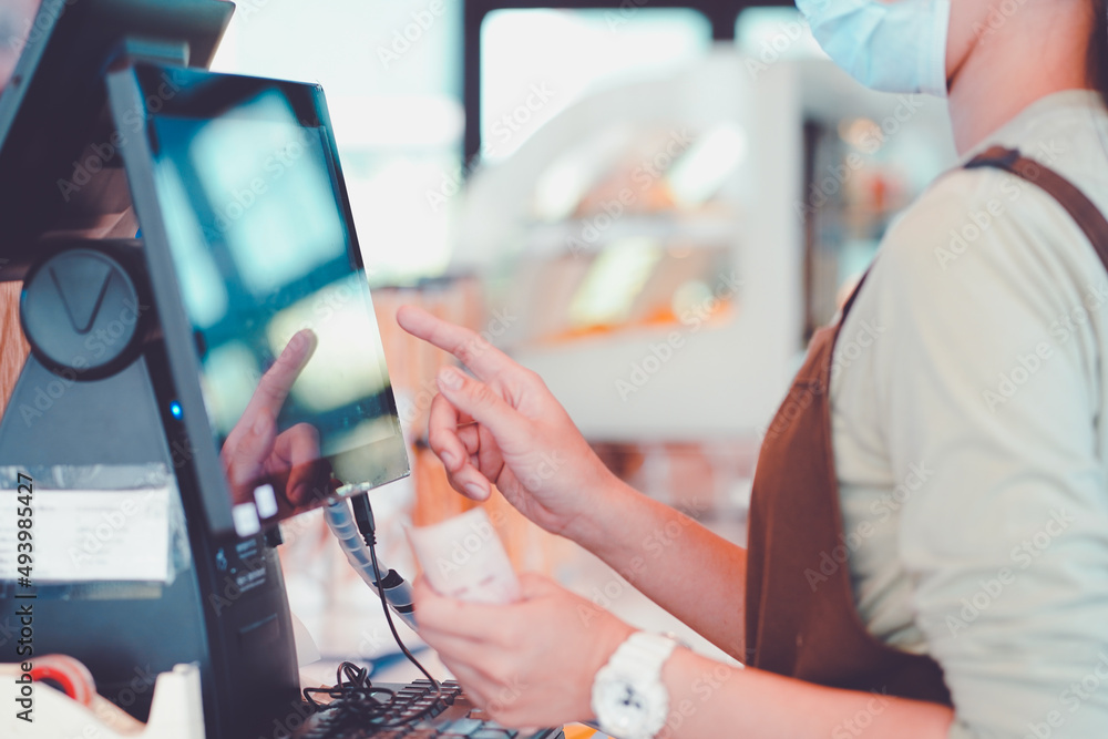 Close up woman cashier using cash register screen to check and pay ...