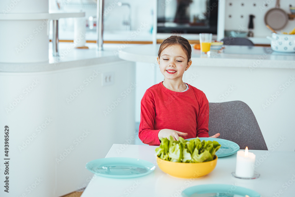 Happylittle girl setting the table for family lunch during holidays ...