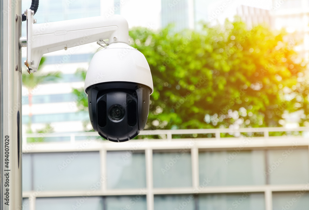 Modern public CCTV camera on electric pole with blur building ...