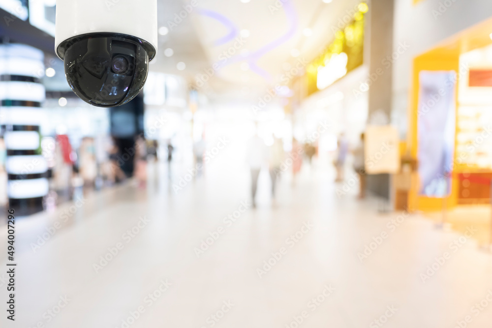 Modern public CCTV camera with blur interior shopping mall background ...