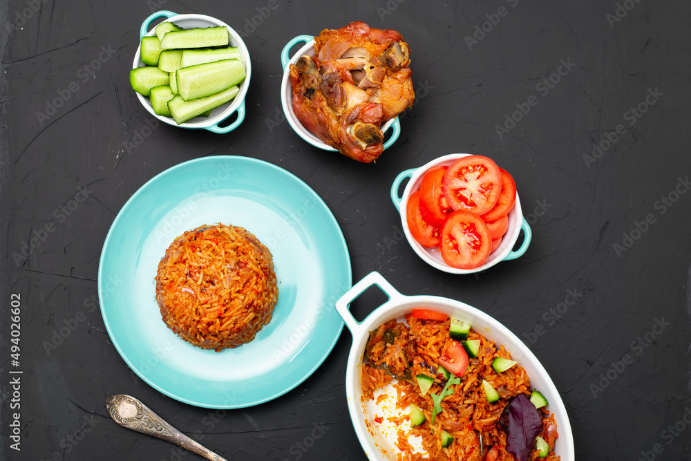 Jollof rice on a plate. Rice with tomatoes, onions, spices. Traditional ...