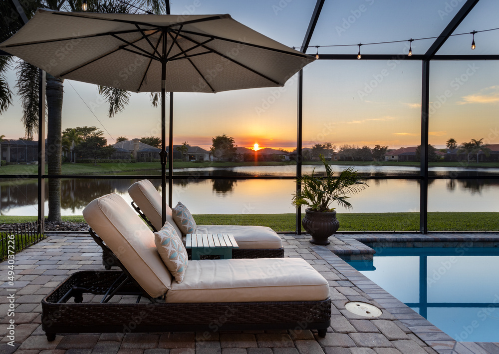 Florida screened swimming pool with lounge chairs overlooking lake at ...