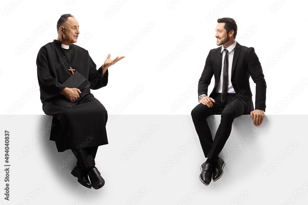 Priest talking to a businessman seated on a blank panel Stock Photo ...