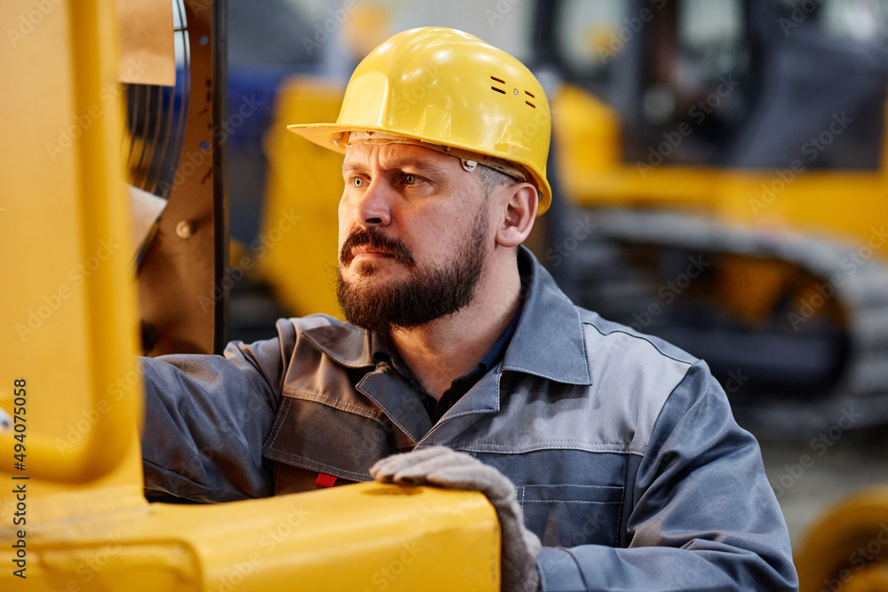 Foto de Serious foreman or repairman in boilersuit and safety helmet ...