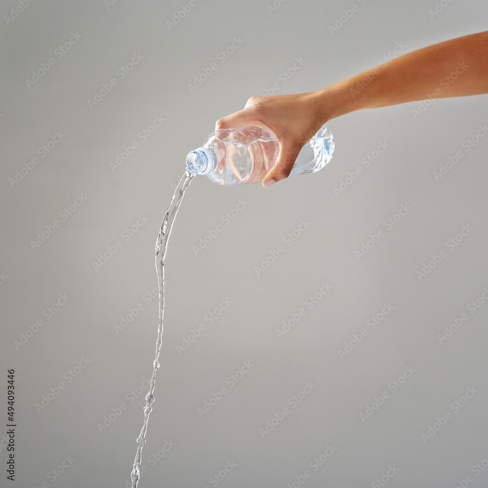 Purified water. Cropped shot of water being poured out of a bottle ...