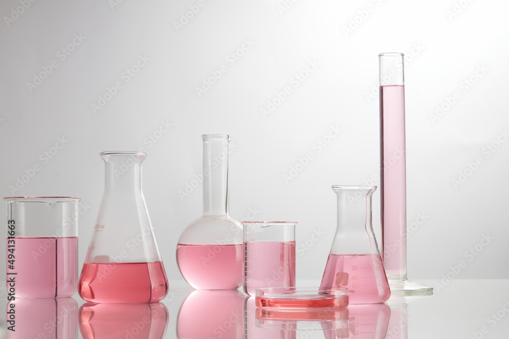 Front view of laboratory equipment filled with pink fluid in a beaker ...