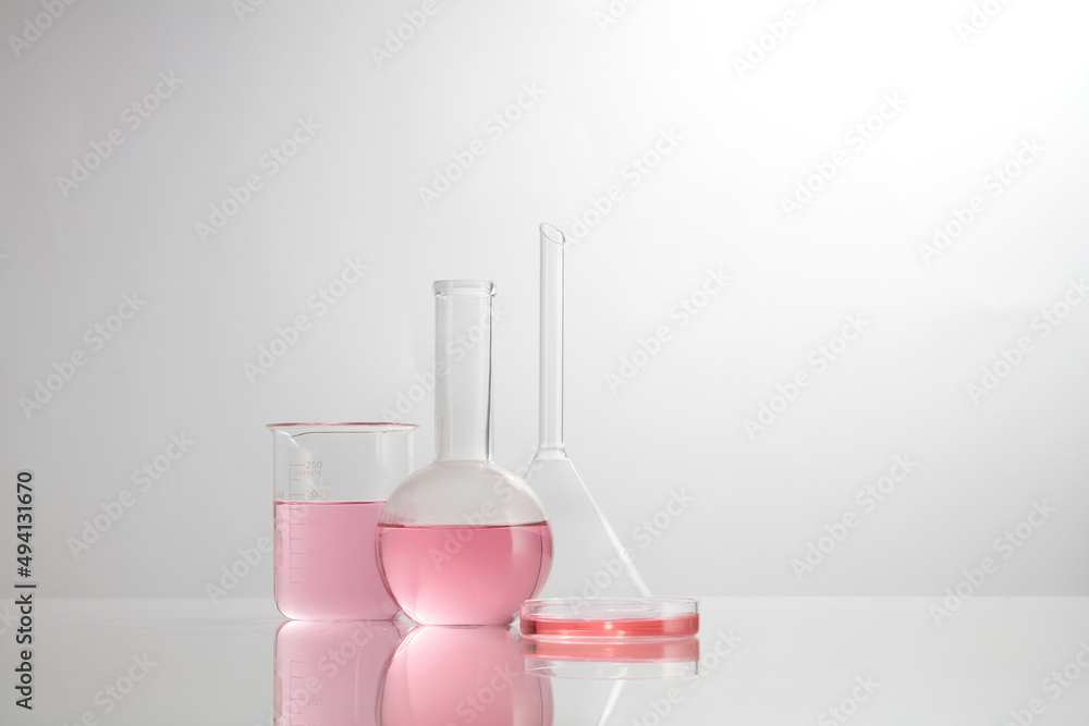 Front view of laboratory equipment filled with pink fluid in a beaker ...