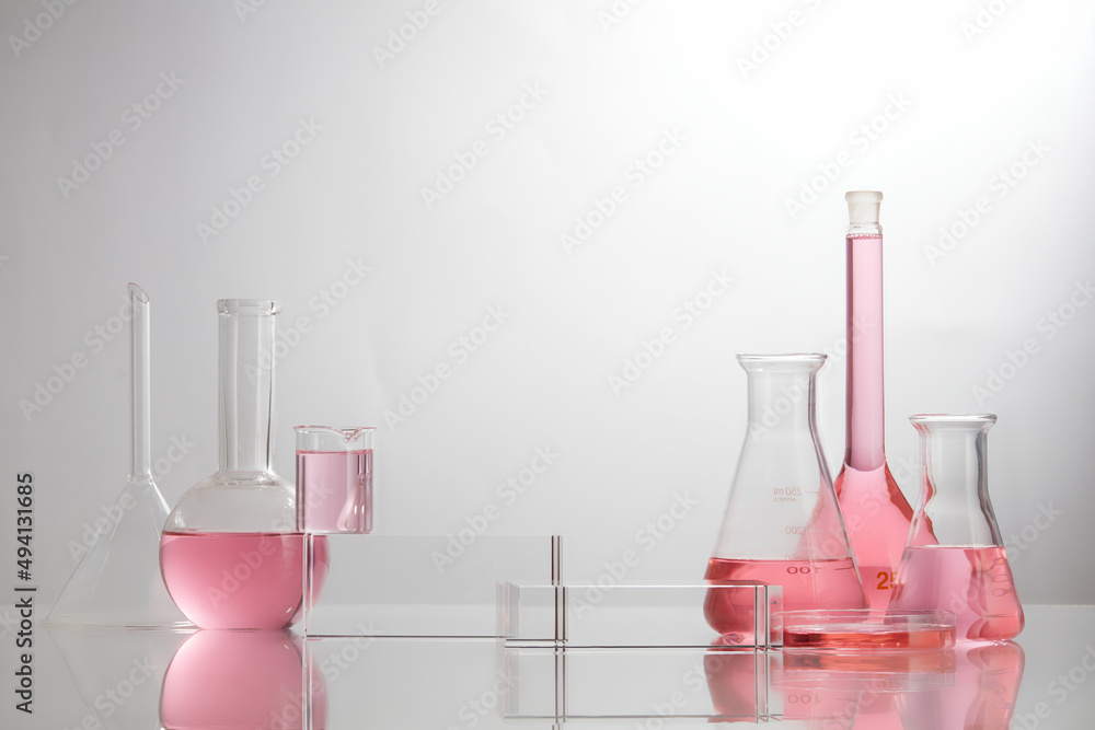 Front view of laboratory equipment filled with pink fluid in a beaker ...