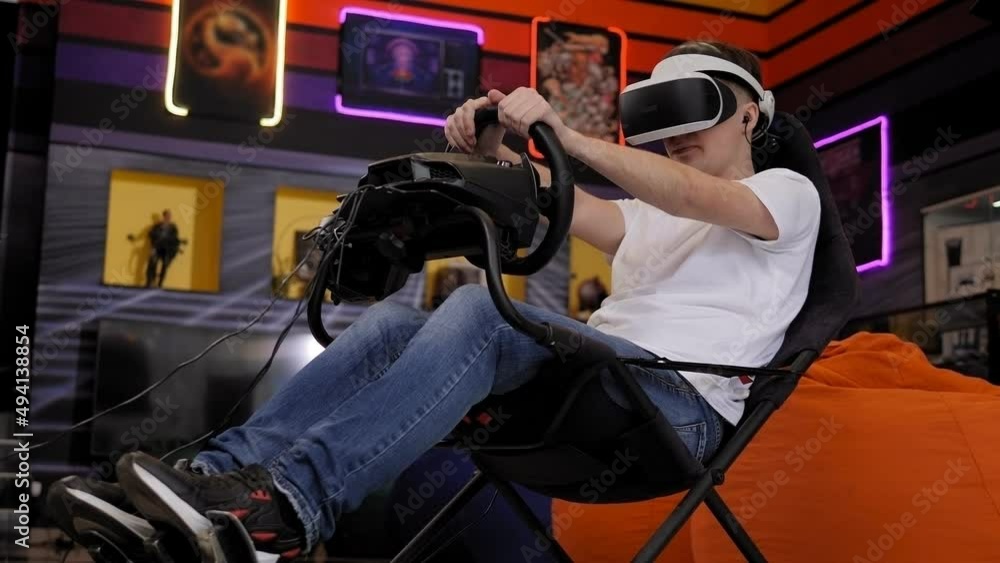 A teenage boy wearing virtual reality glasses sits in a car driving ...