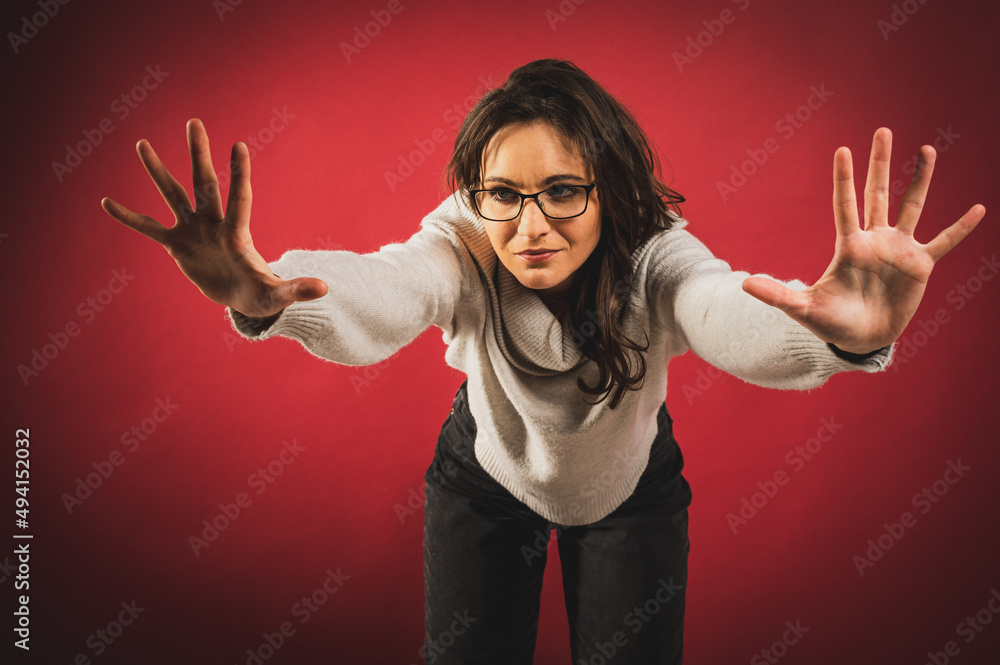 The pretty girl, emotional on a red-cherry background, put her hands ...