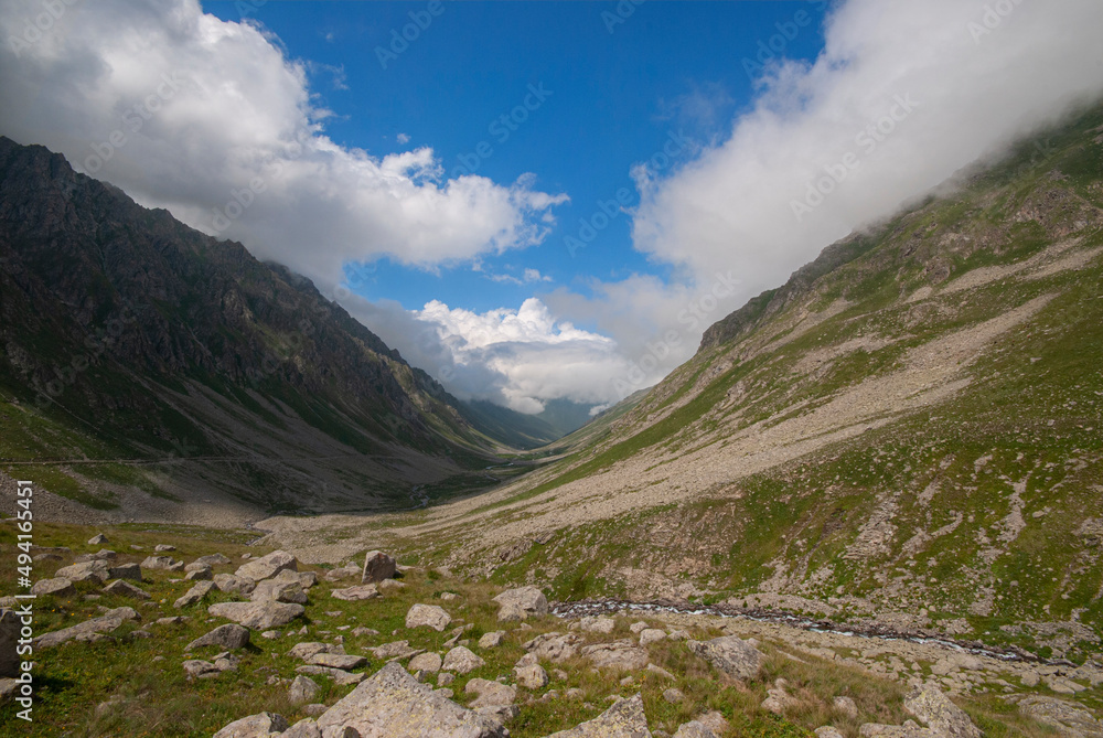 Walking towards the summit among giant moss-covered boulders. Walking ...
