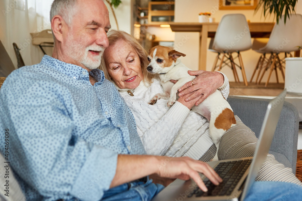 Senior retired couple with dog on sofa Stock Photo | Adobe Stock