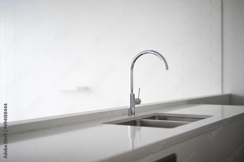 Silver chrome tap on double sink kitchen benchtop white stone flowing ...