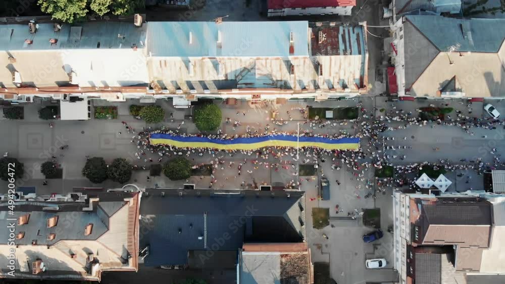 Drone shot of many people holding a huge flag of Ukraine in Sumy. A ...