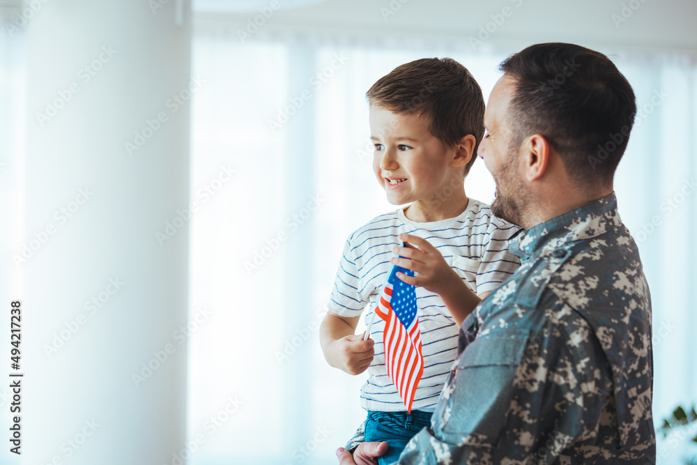 Young soldier just arrived home and he is so happy to see his son ...