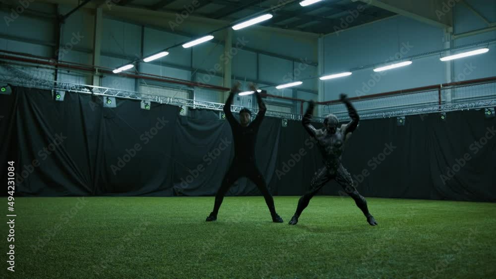 Actor in motion capture suit performing some stunt moves next to a sci ...
