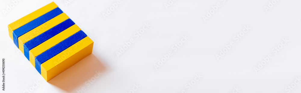 top view of tetragonal blue and yellow blocks on white background ...