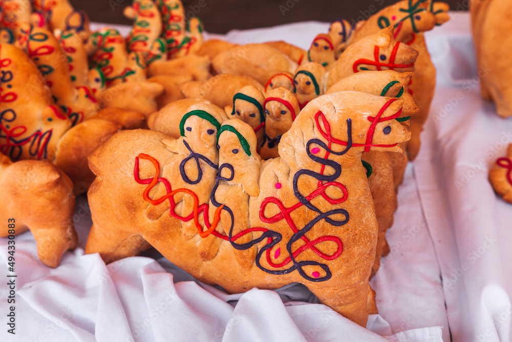 Guaguas de pan hechas de harina y decoradas con masa de colores que se ...